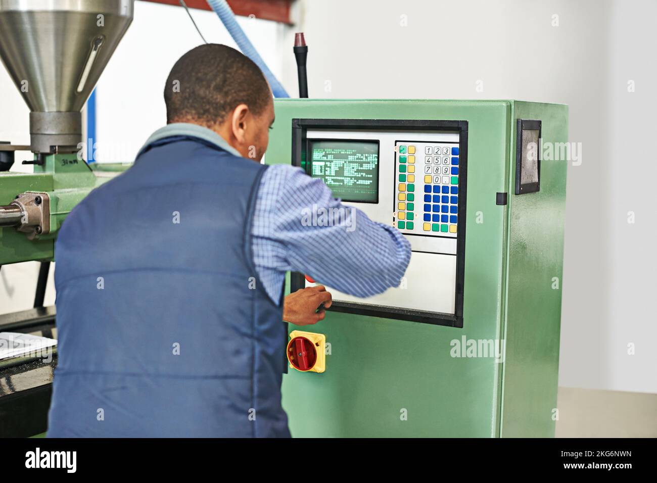 All systems are ready. a man working over factory machinery Stock Photo ...