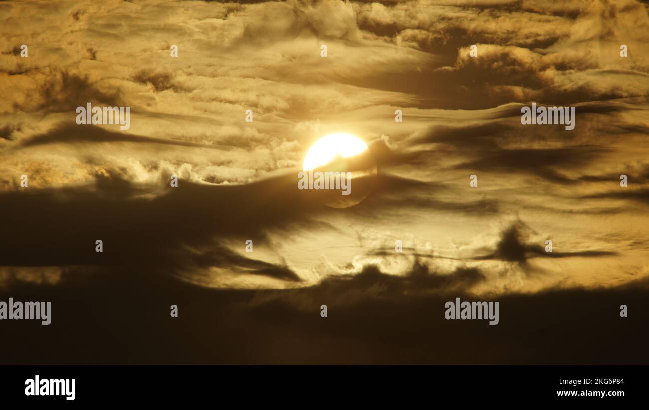 The Sun in all its splendor peeking through a woven blanket of clouds ...