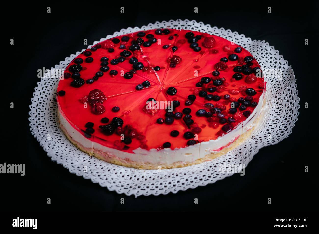 A cheesecake with berries and red jelly on a black background Stock ...