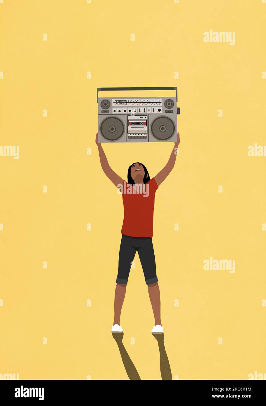 Carefree woman holding boom box overhead on yellow background Stock ...