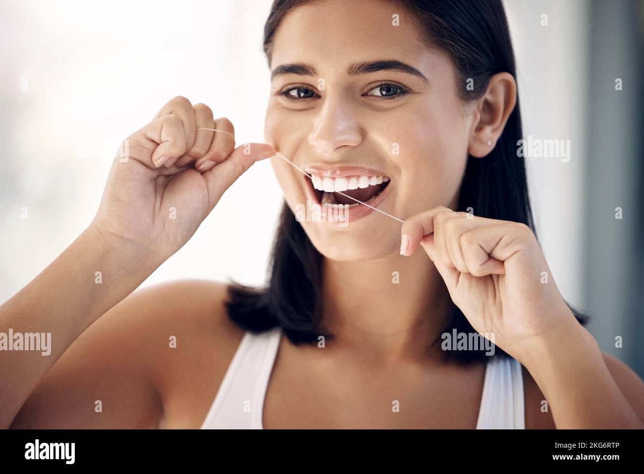 Floss, teeth and dental with woman in bathroom for morning routine, oral hygiene and healthy ...