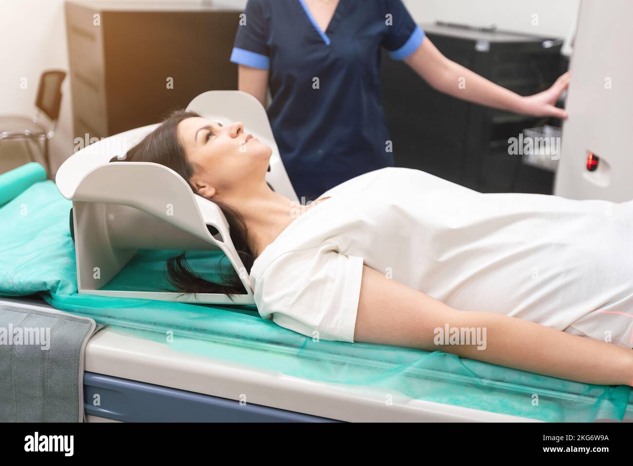 A woman lies on the tomograph table. woman is undergoing computed axial ...