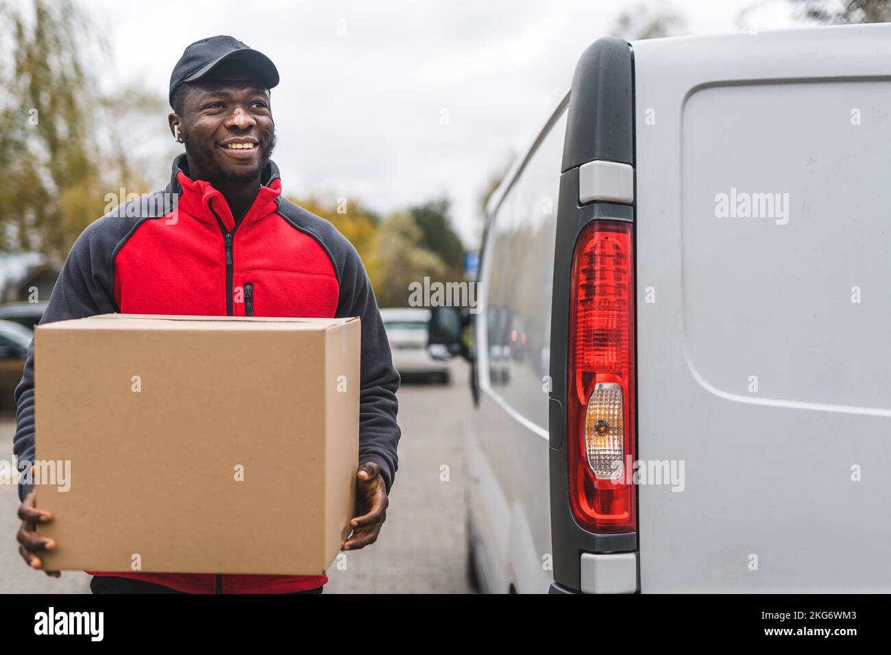 Black delivery man holding package hi-res stock photography and images ...