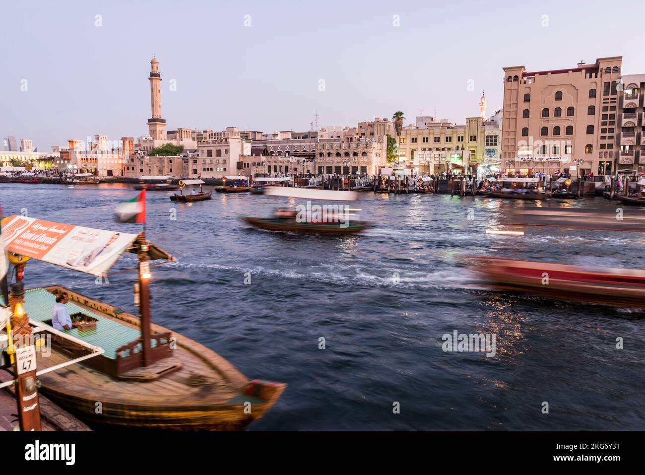 view of Bur Dubai at sunset with water taxi called Abra used by ...