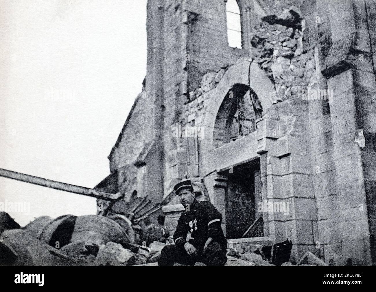A French soldier sitting next to the fallen bells of a ruined church in ...