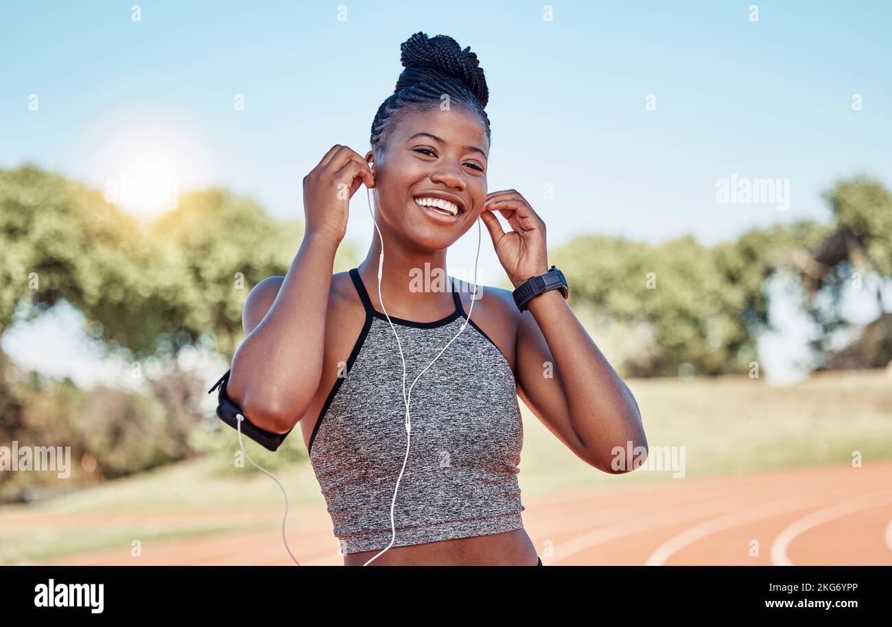 Running, portrait of woman on track with headphones and phone for ...