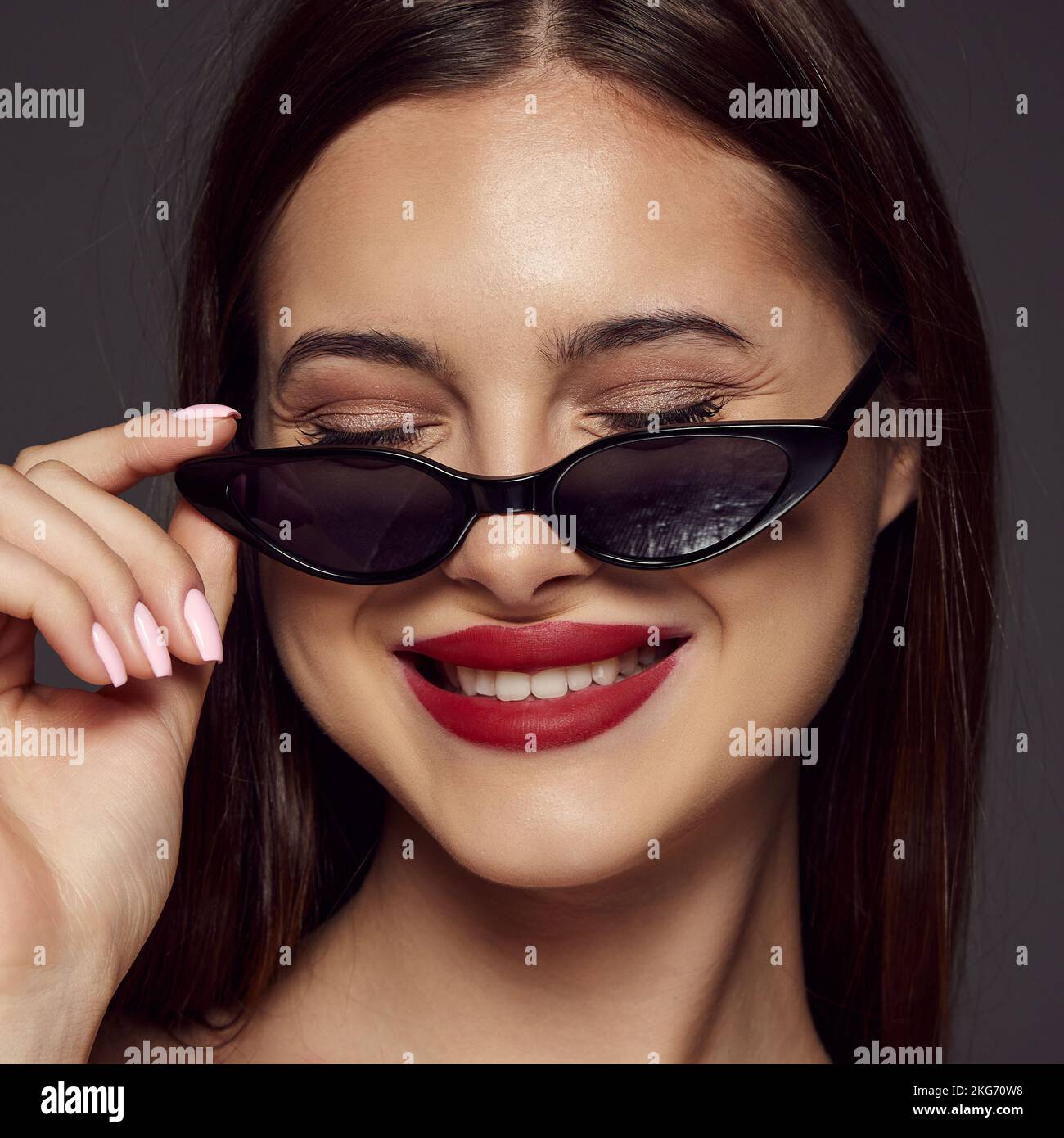 Close-up portrait of young beautiful girl with red lips posing in ...
