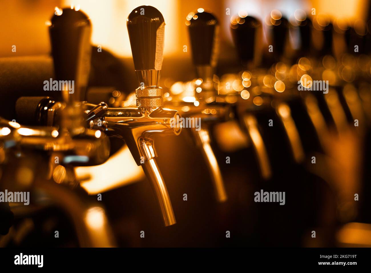 Creatively blurred image of faucets in beer pub with defocused bokeh ...