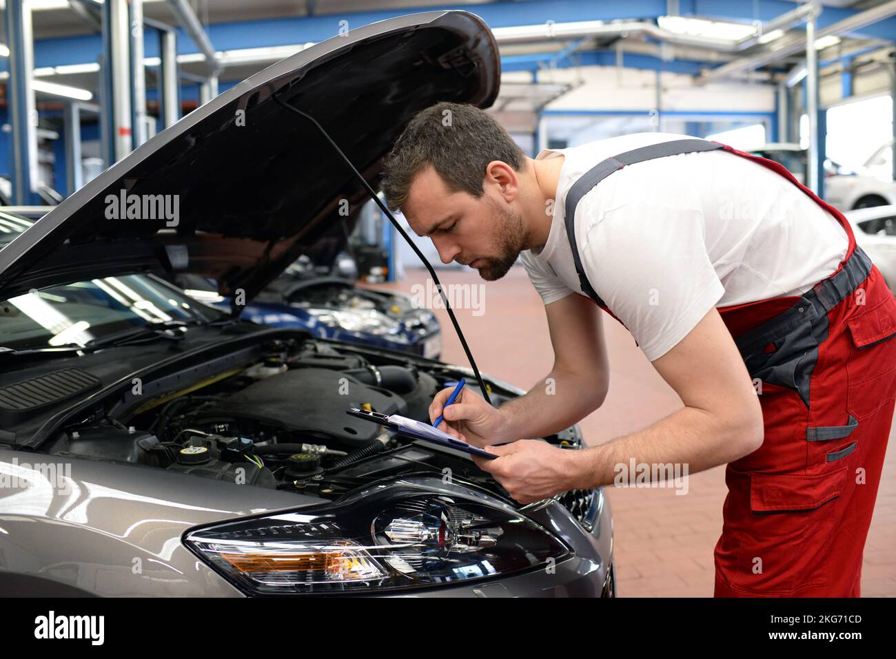 mechanic in a workshop checks and inspects a vehicle for defects Stock ...