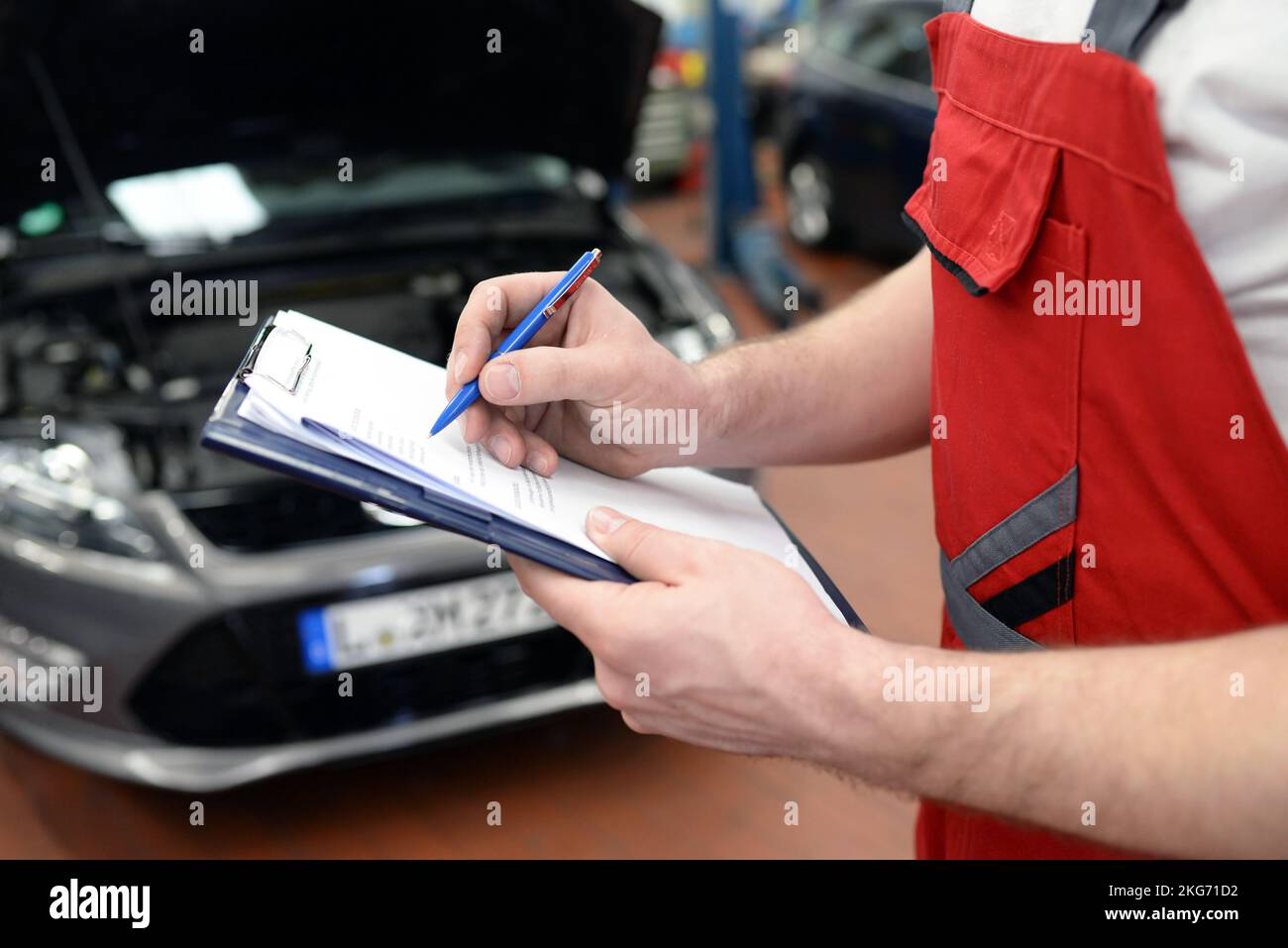 mechanic in a workshop checks and inspects a vehicle for defects Stock ...