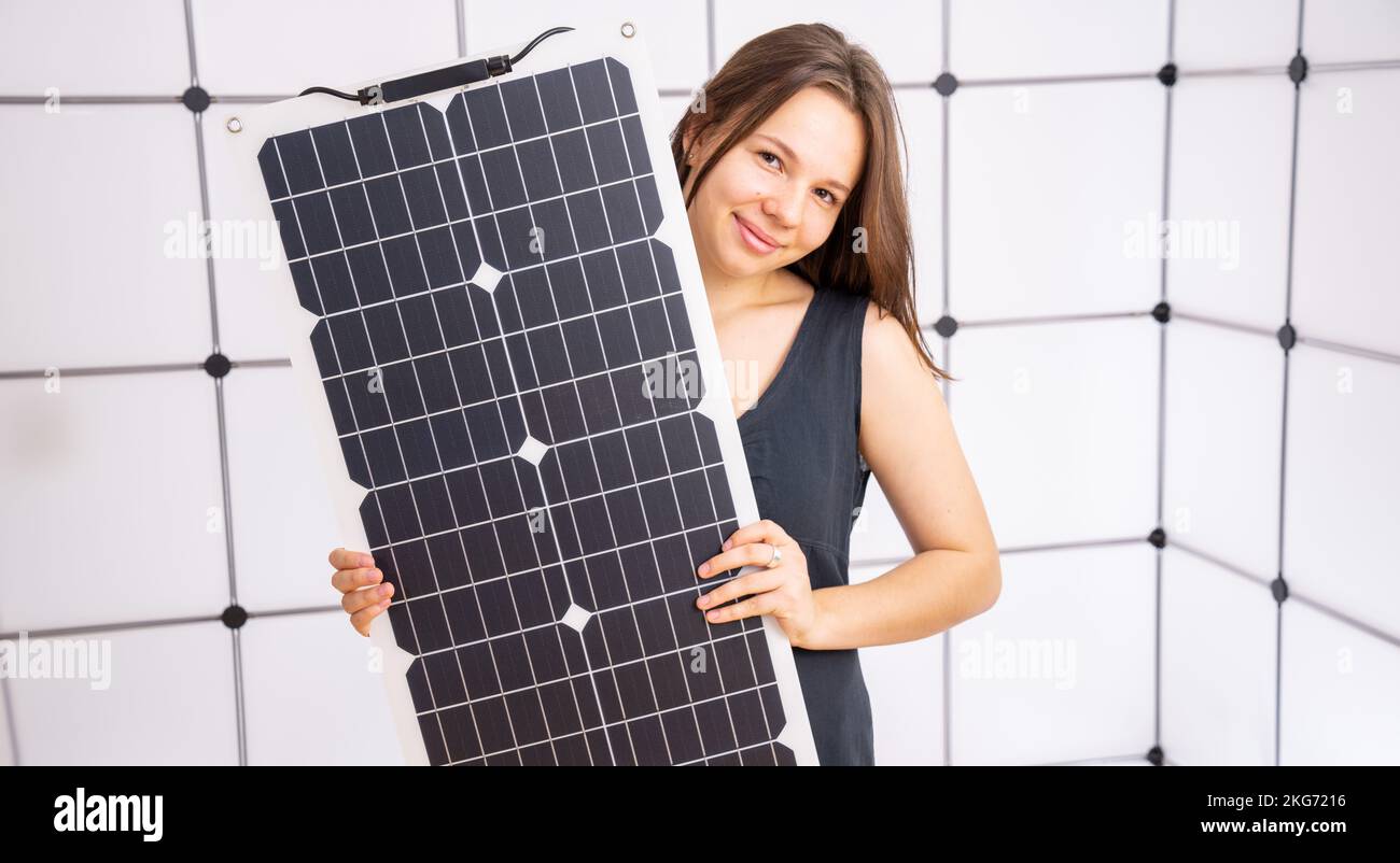 young woman in black dress holding a flexible solar panel Stock Photo ...