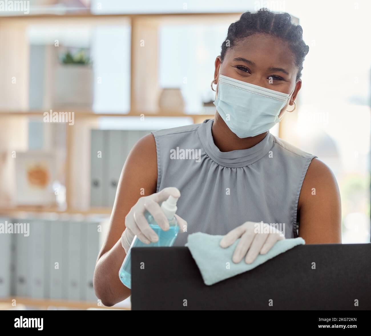 Covid, mask and sanitizer with a business black woman cleaning her ...