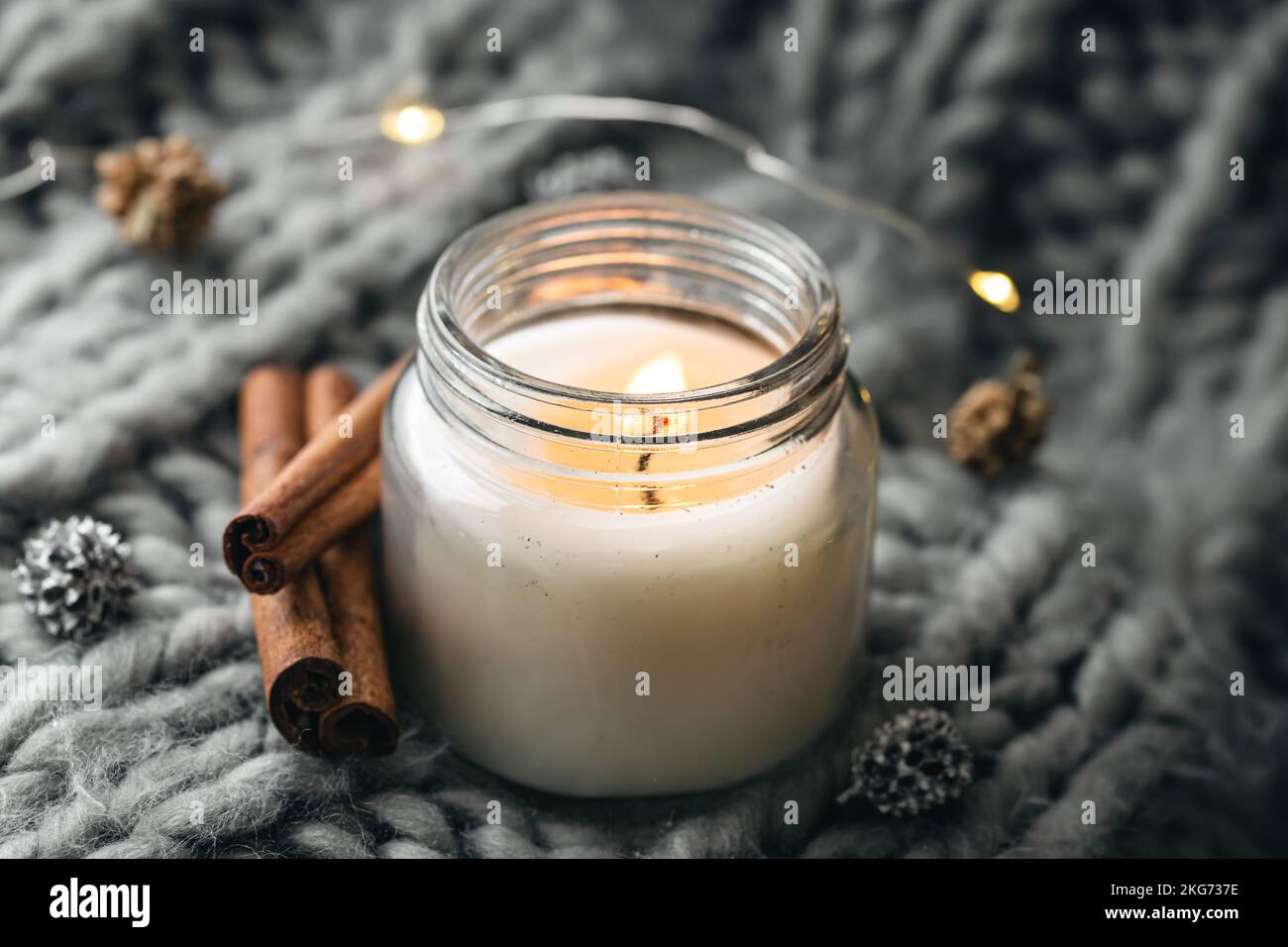 Close-up, candle and cinnamon sticks on the background of a gray ...