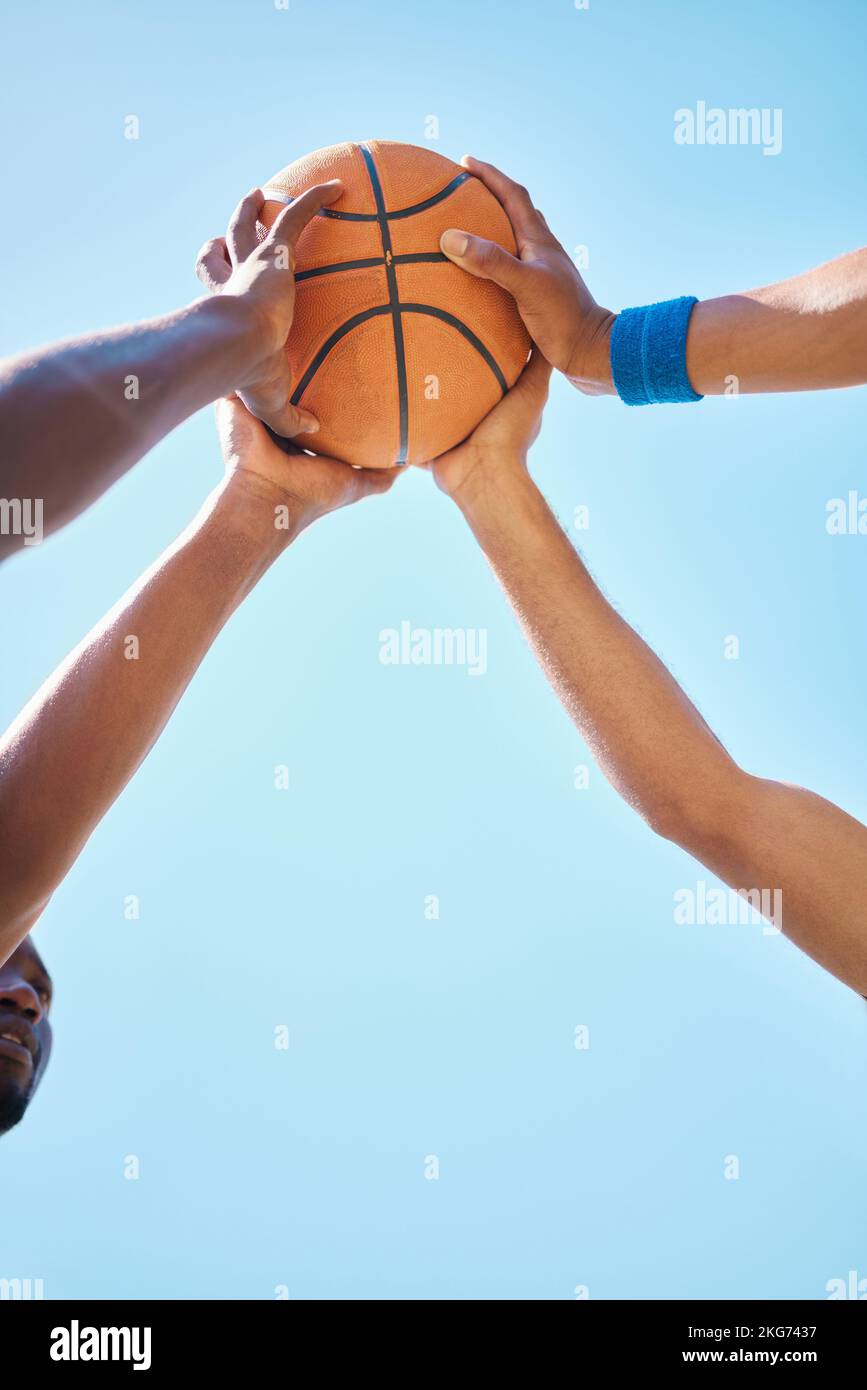 Teamwork, sports and hands on basketball ball with blue sky background ...