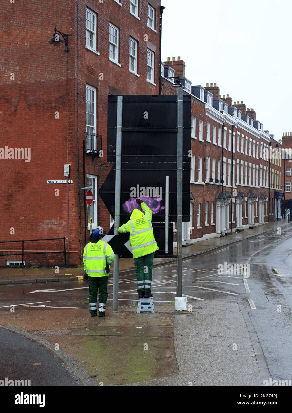 Worcester city council workers removing graffiti from a road sign in ... Worcester city council workers removing graffiti from a road sign in ...