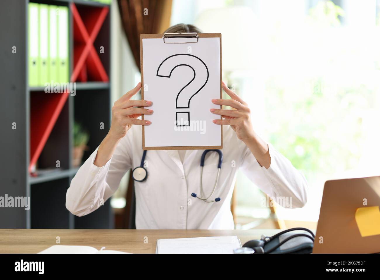 Woman practitioner covering face with paper with question mark Stock ...