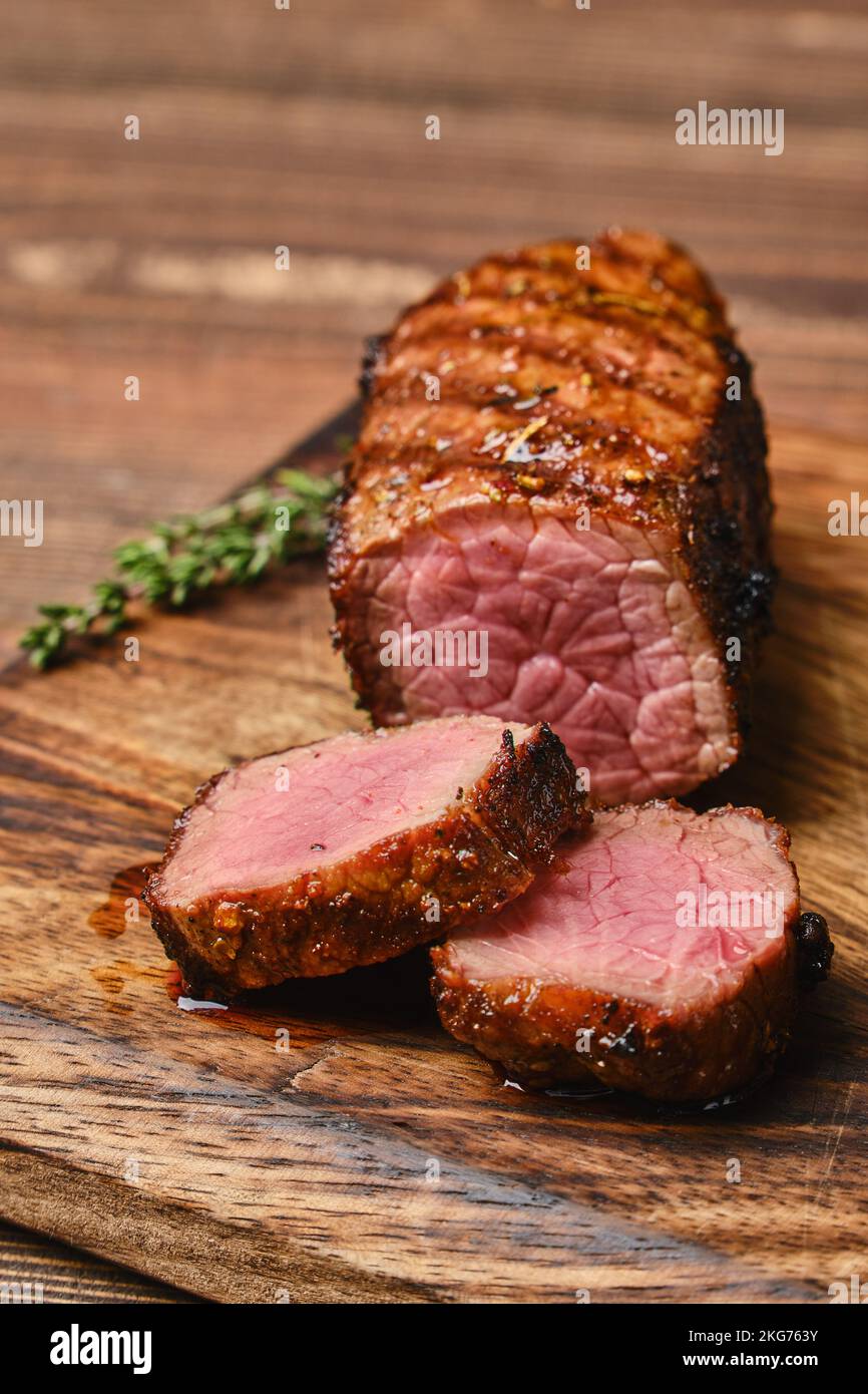Closeup view of juicy roasted beef brisket flat steak on wooden cutting ...