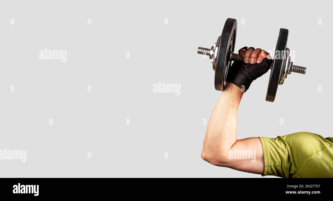 Arm hand lifting dumbbell close up, pumping shoulders, biceps, muscles ...