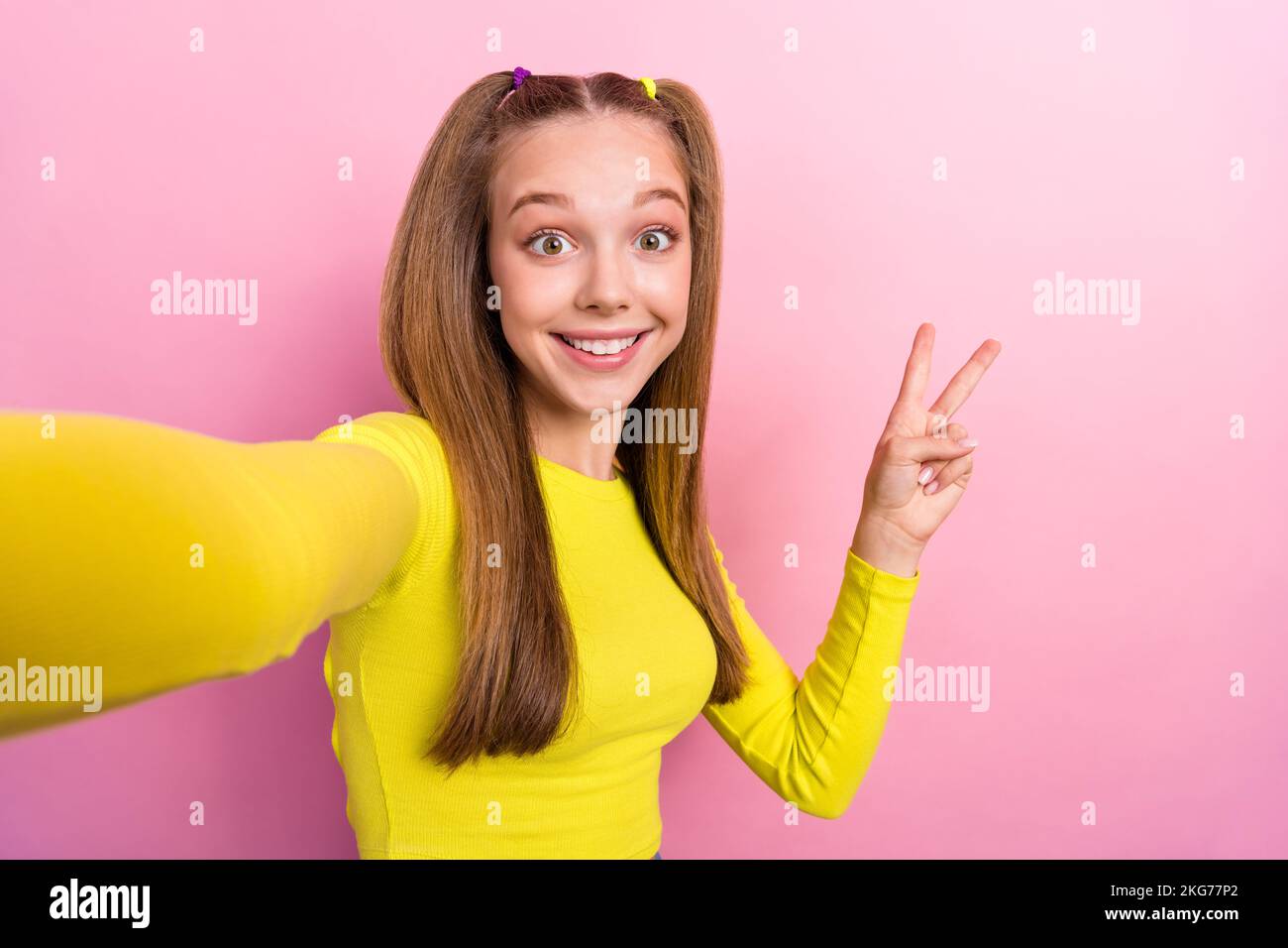 Portrait of cute cheerful girl with ponytails dressed yellow long ...