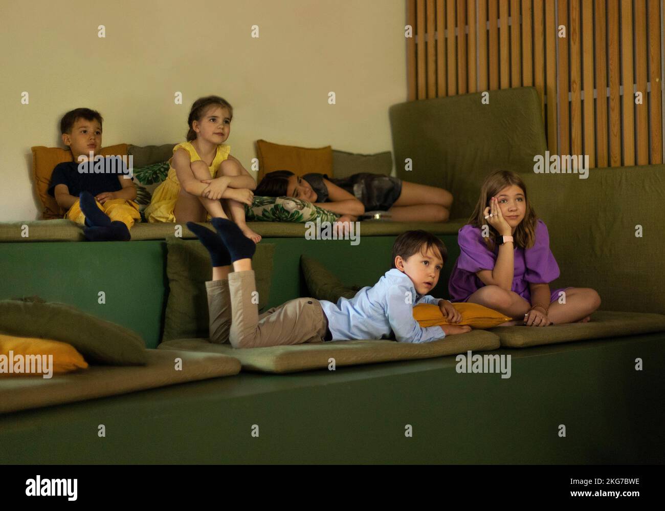 Little boys and girls look shocked and surprised watching movie in home ...