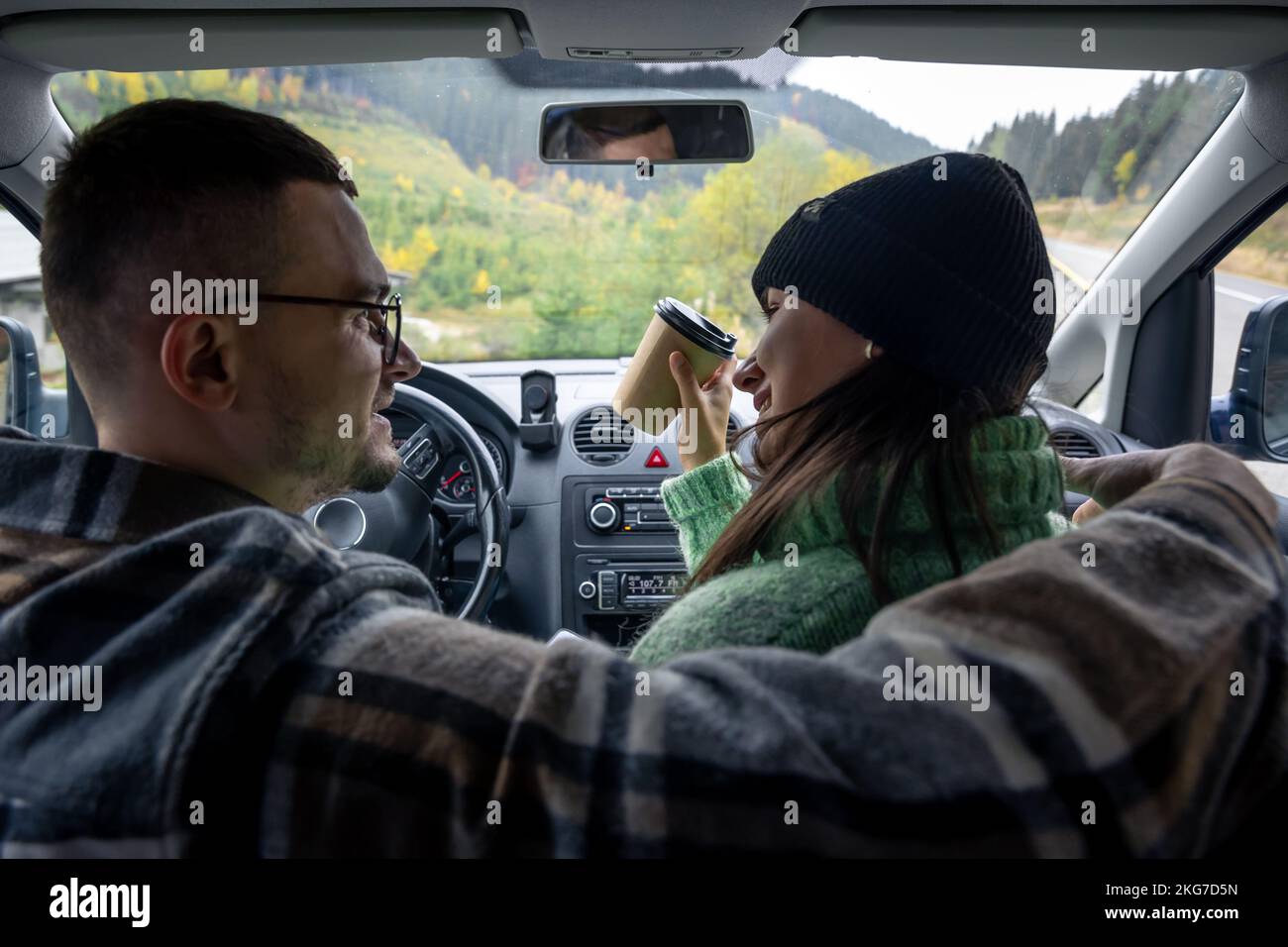 Rear back view from passenger seat of man and lady sitting inside car ...