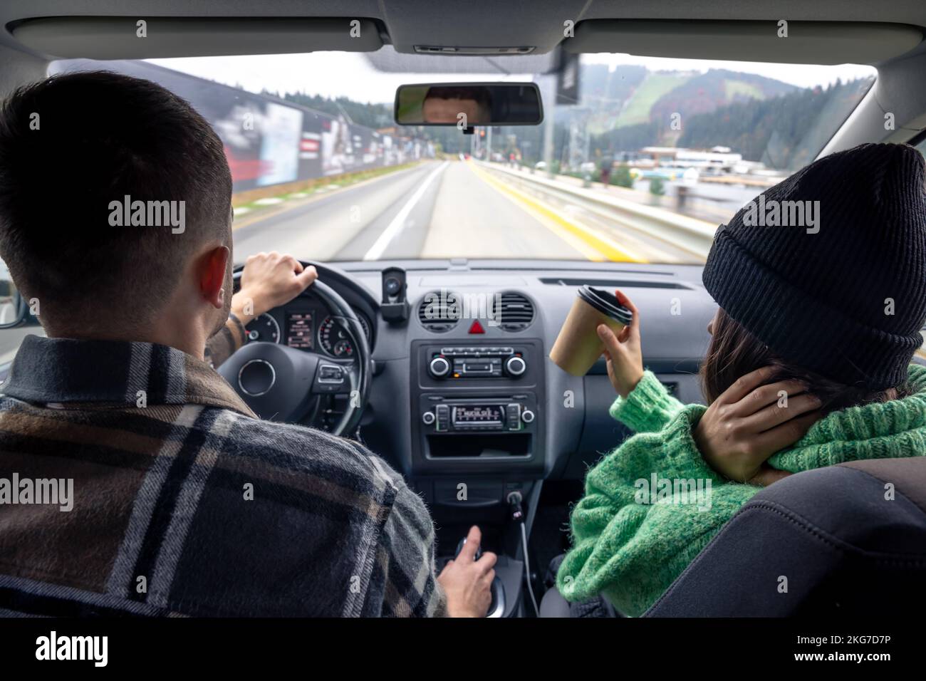 Rear back view from passenger seat of man and lady sitting inside car ...