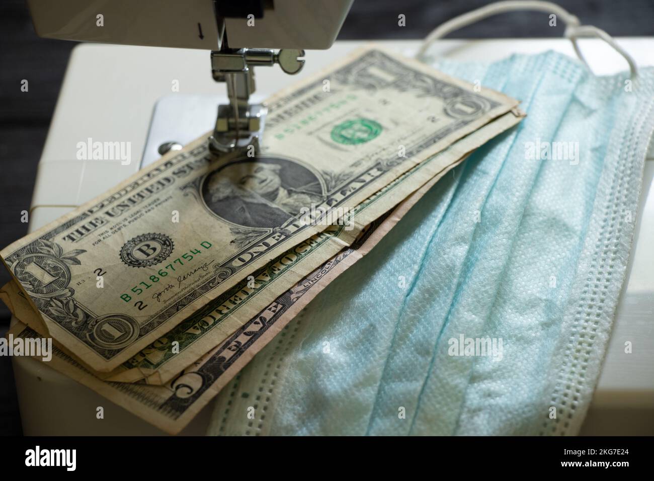 American dollars lie next to medical masks on a sewing machine ...