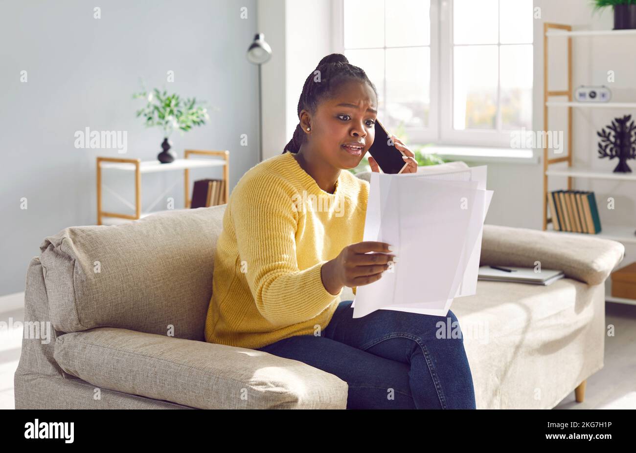 Stressed worried woman holding her bills and making phone call to ...