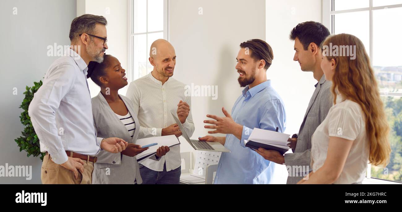 Group of business people discuss something in office standing near ...