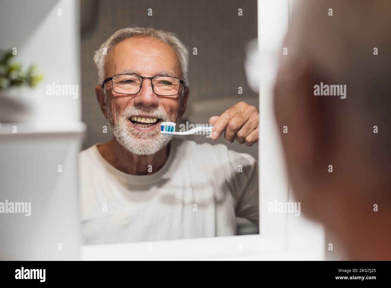 Senior man is cleaning his teeth in bathroom. Dental hygiene Stock ...