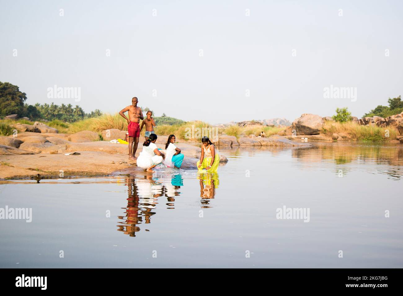 Happy Indian people at the river colorfully dressed washing clothes in ...