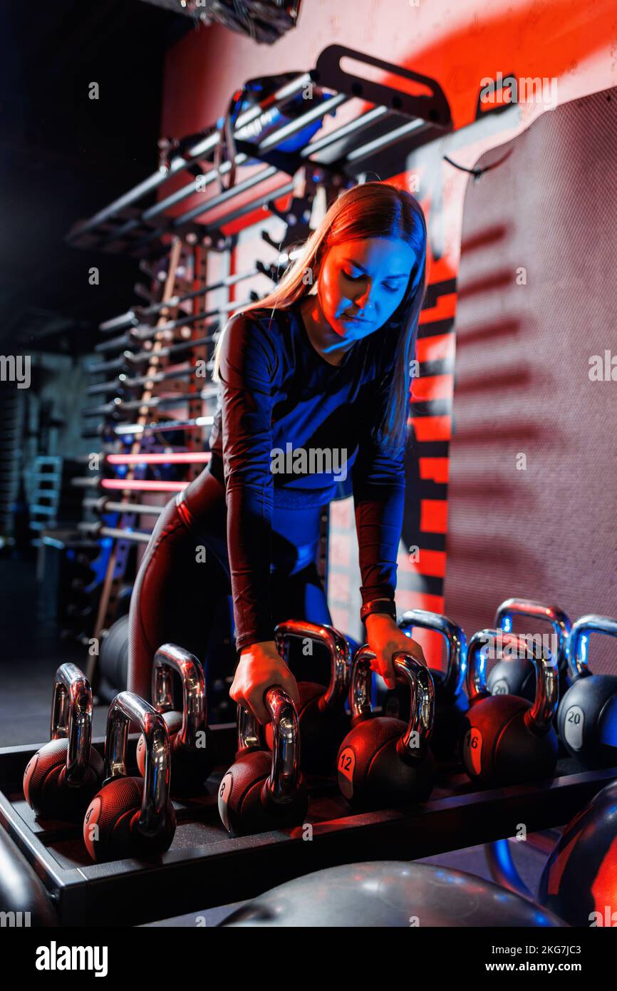 Weights with different weights. Sports equipment in the gym. A woman ...