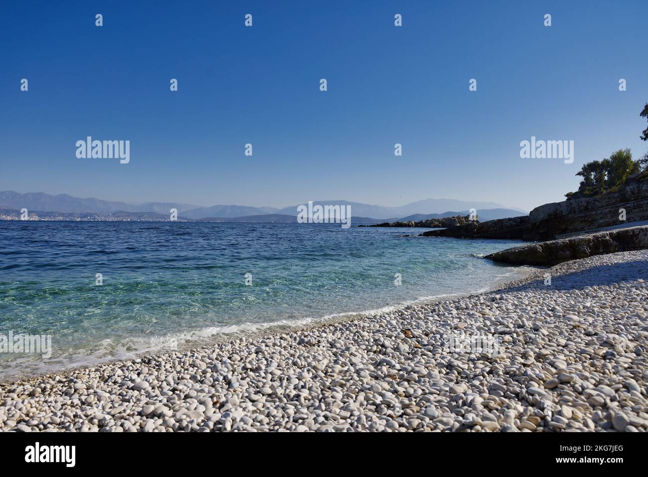 A beautiful scene of sandy beach by the sea with green beach with ...