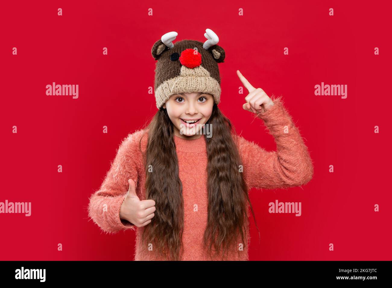 teen child wear sweater and winter fashion hat in studio. pointing ...