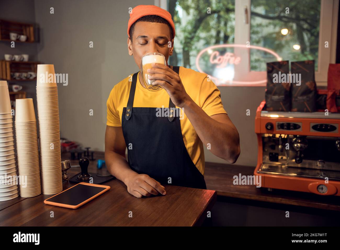 Cafe worker sipping coffee in the workplace Stock Photo - Alamy
