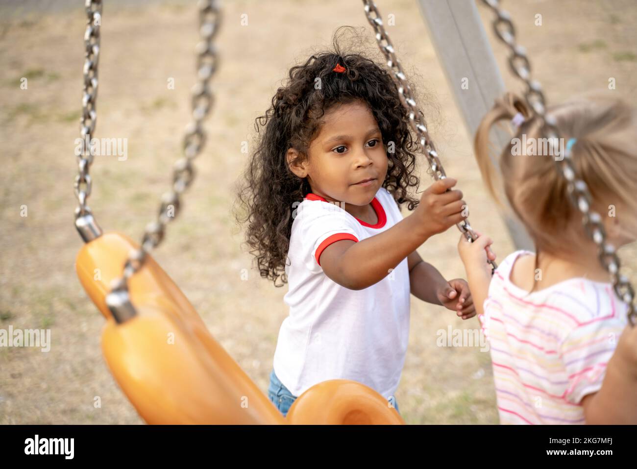 Cute kid playing with her friend outdoors Stock Photo - Alamy