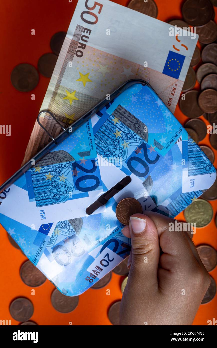 Money box with coins and banknotes on orange background Stock Photo - Alamy