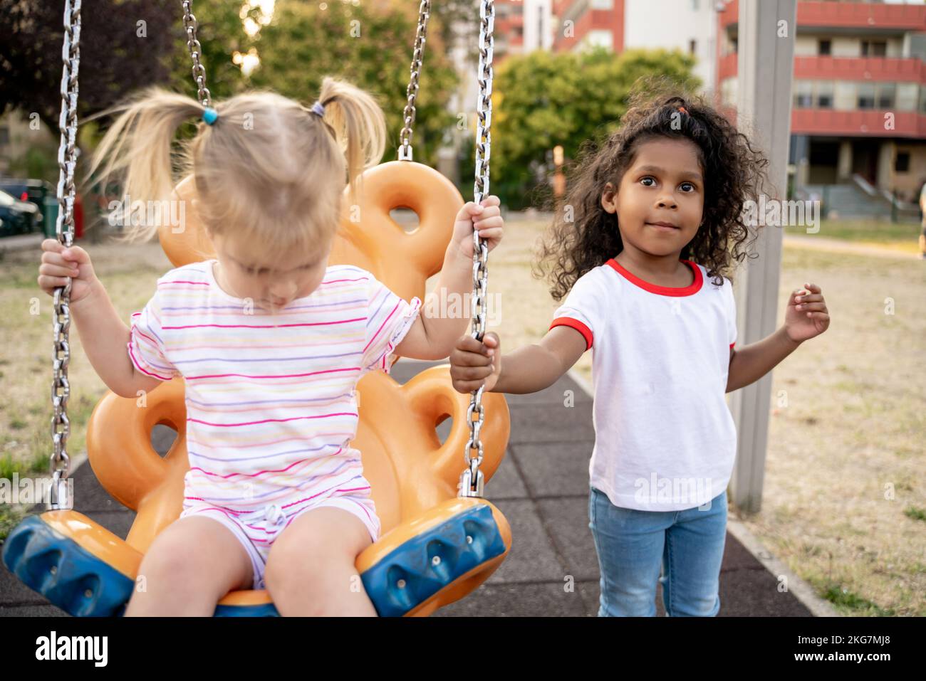 Two kids playing together on the playground Stock Photo - Alamy