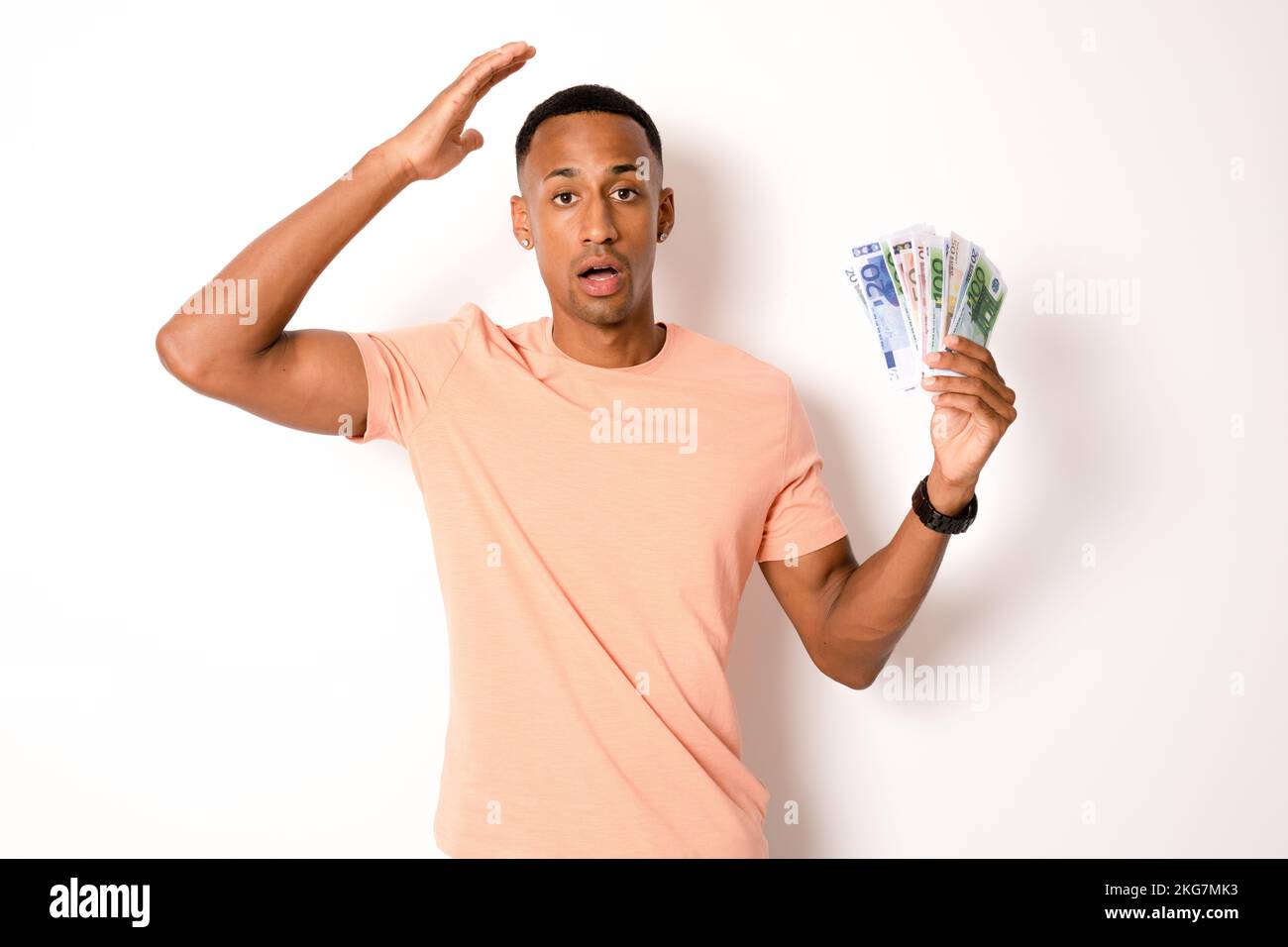 Young man with money standing isolated over white background Stock ...