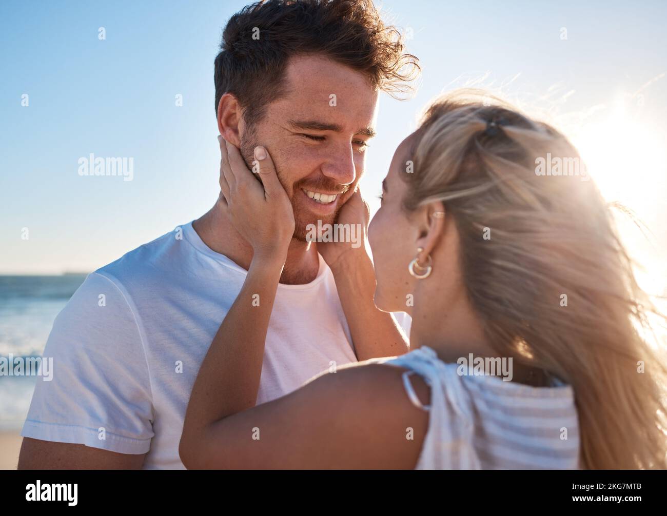 Woman, man and touch face, love and happy together at the beach, travel ...