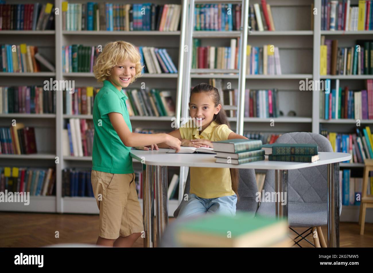 Classmates reading together in a school library Stock Photo - Alamy