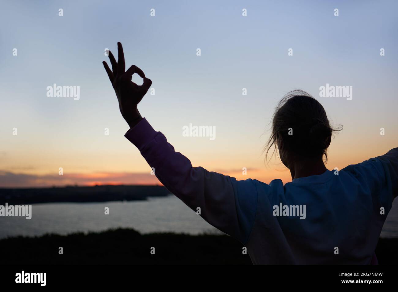 closeup of the silhouette of a woman performing a yoga asana at sunrise ...