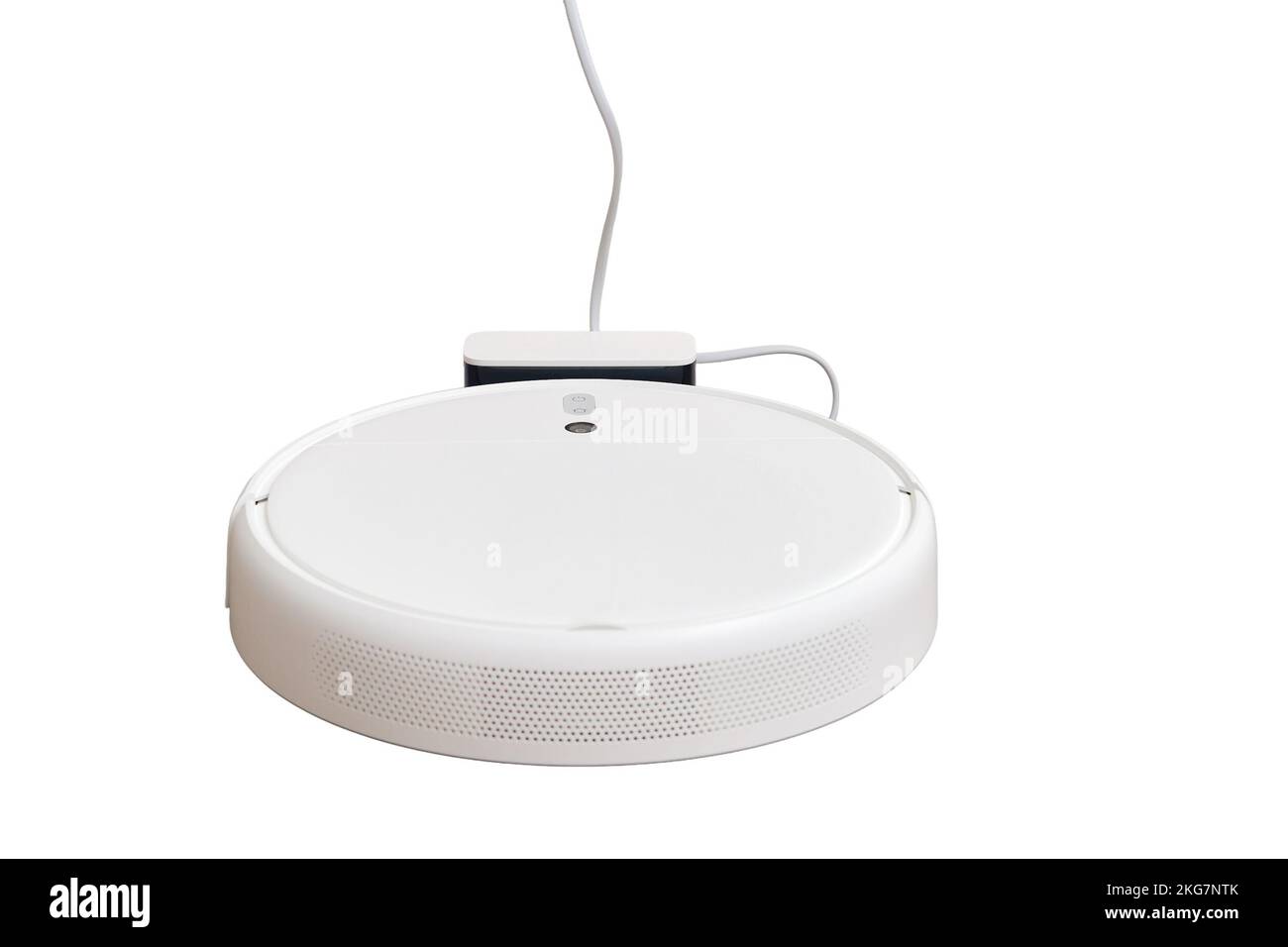 White robotic vacuum cleaner is charged from an electrical outlet on ...