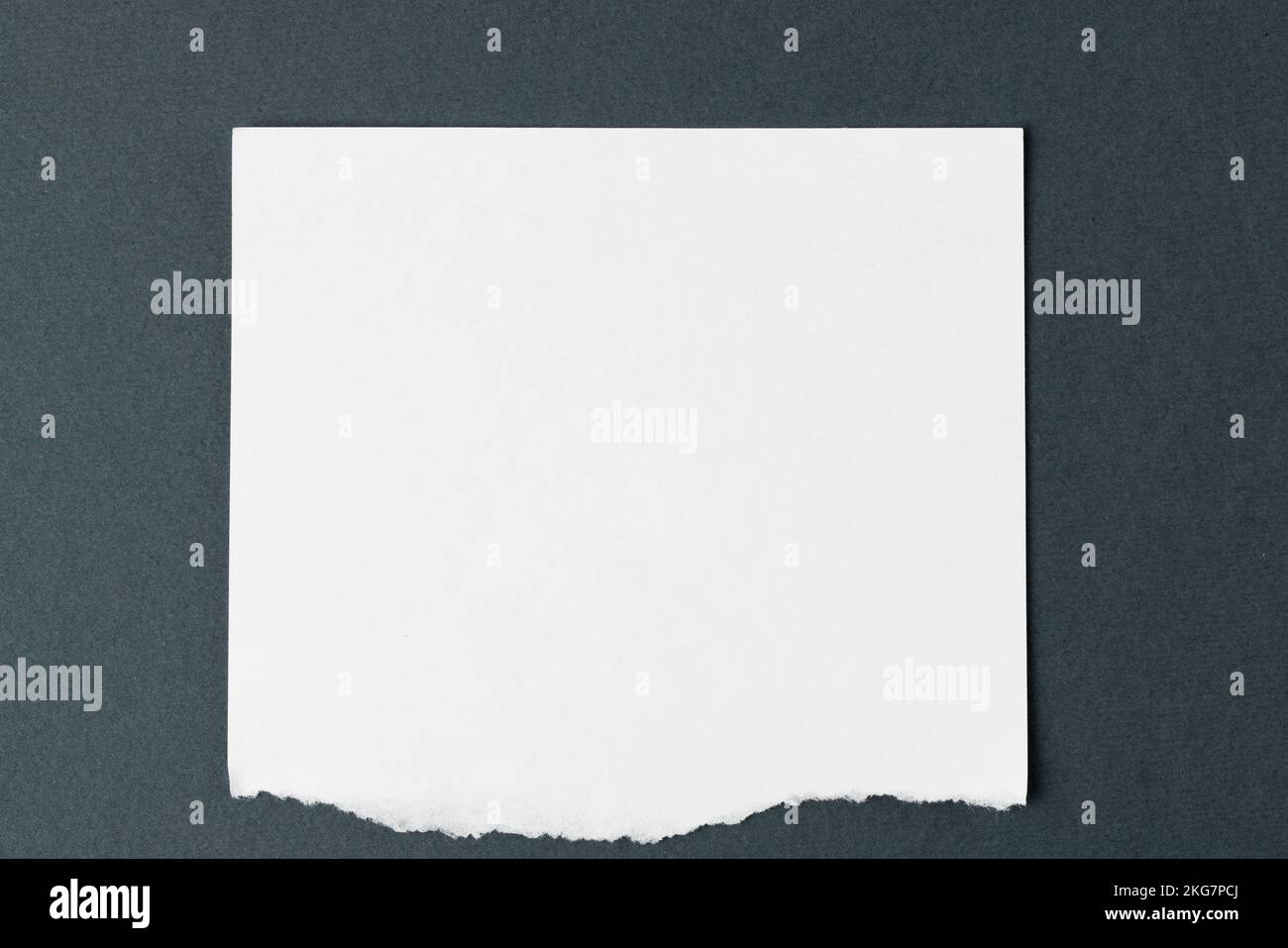 Ripped up piece of white paper with copy space on black background ...