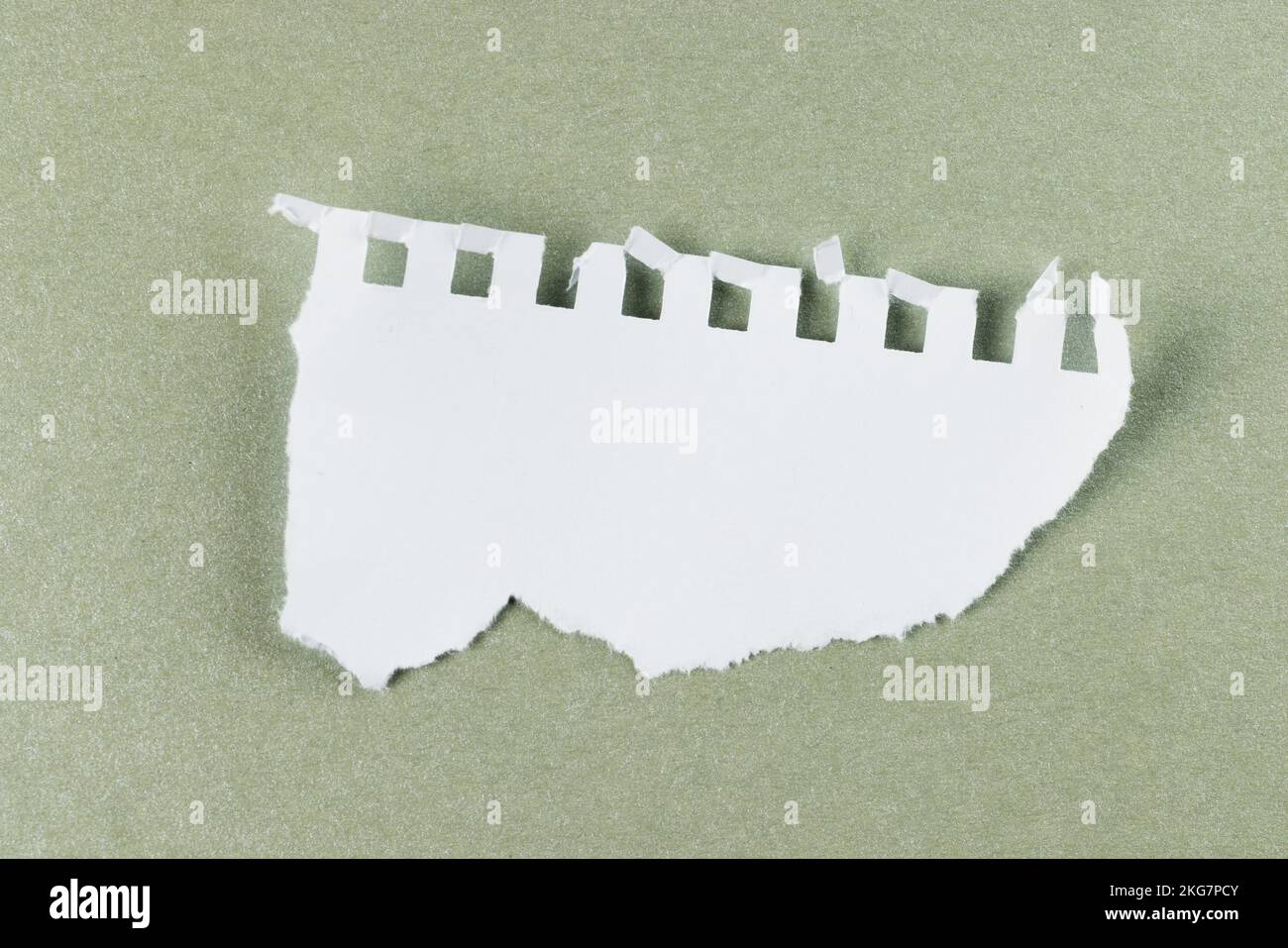 Ripped up piece of white paper with copy space on cardboard background ...