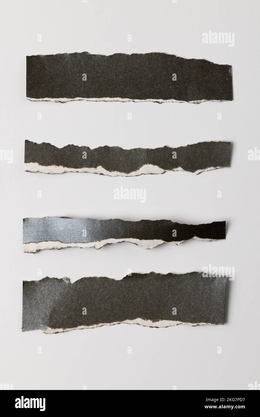 Ripped up pieces of black paper with copy space on white background ...