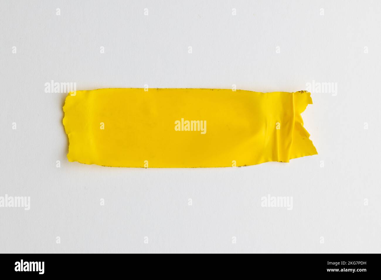 Ripped up piece of yellow tape with copy space on white background ...