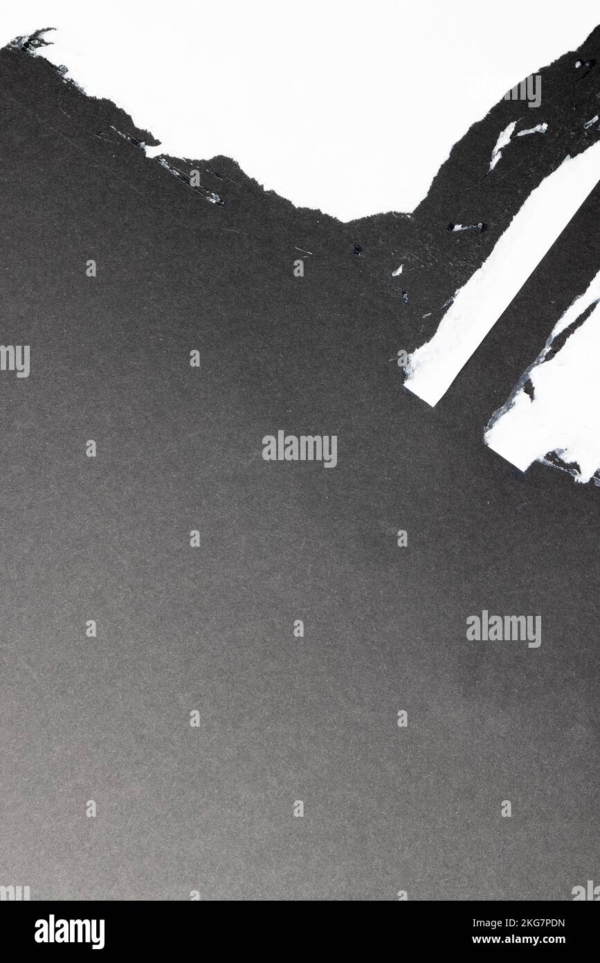 Ripped up pieces of white paper with copy space on black background ...