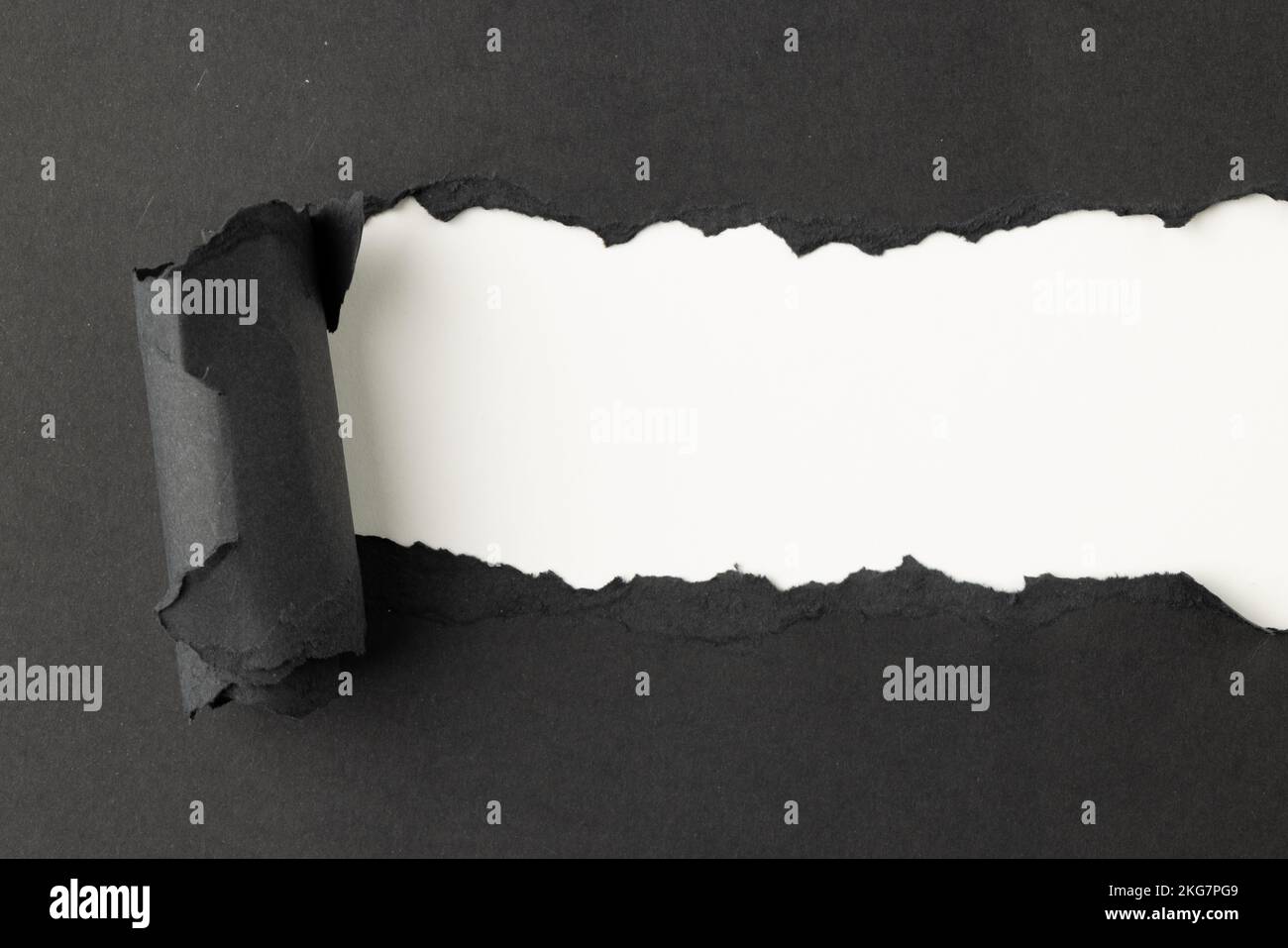 Ripped up piece of black paper with copy space on white background ...