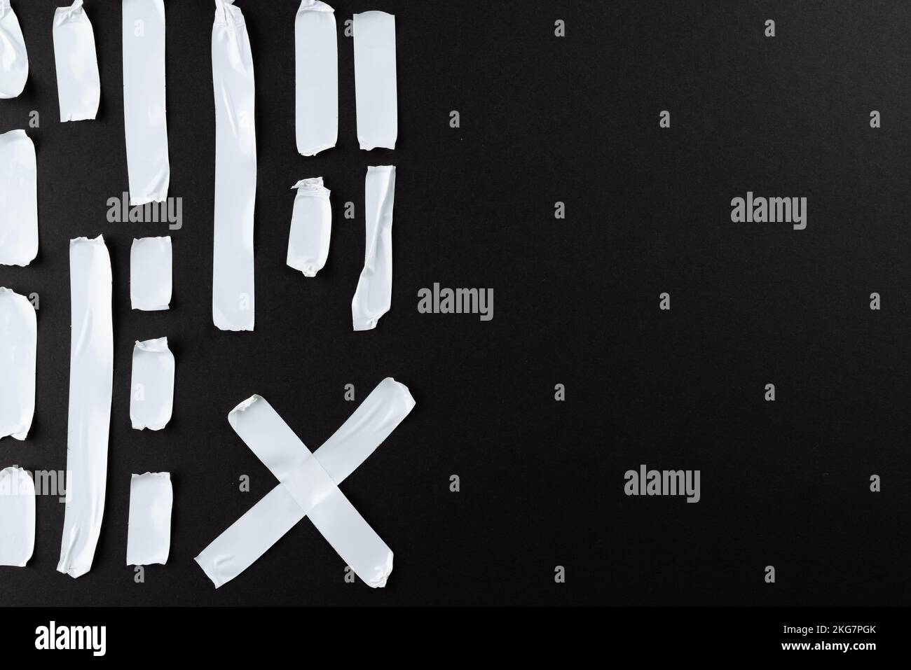 Ripped up pieces of white tape with copy space on black background ...